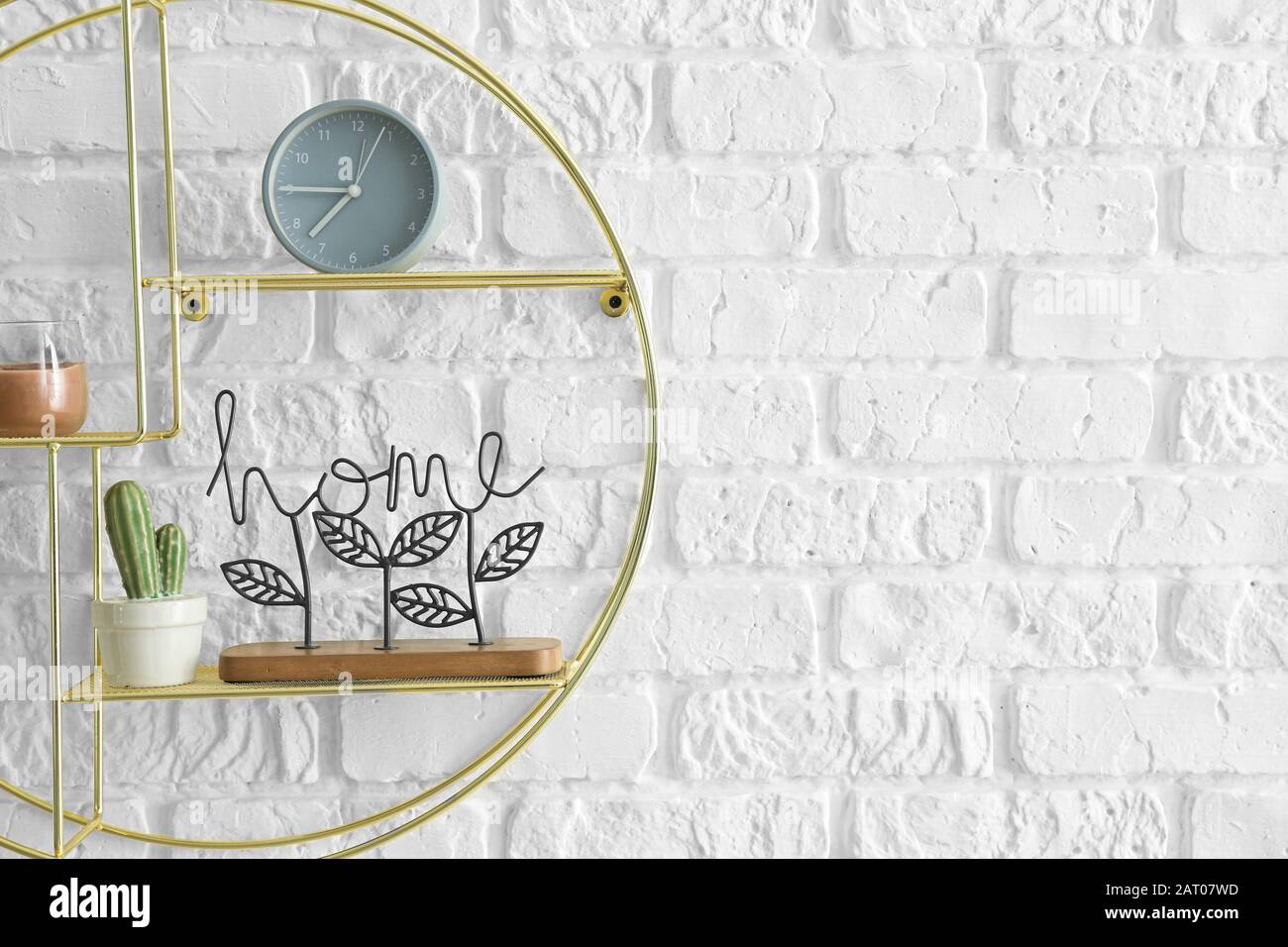 Shelf with decor hanging on white brick wall Stock Photo - Alamy