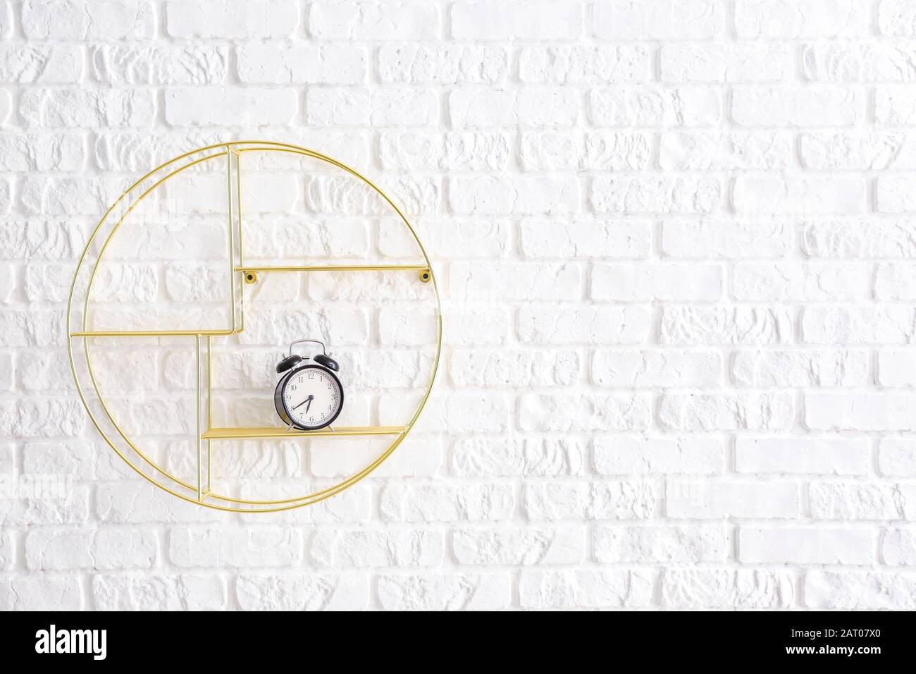Shelf with clock hanging on white brick wall Stock Photo - Alamy