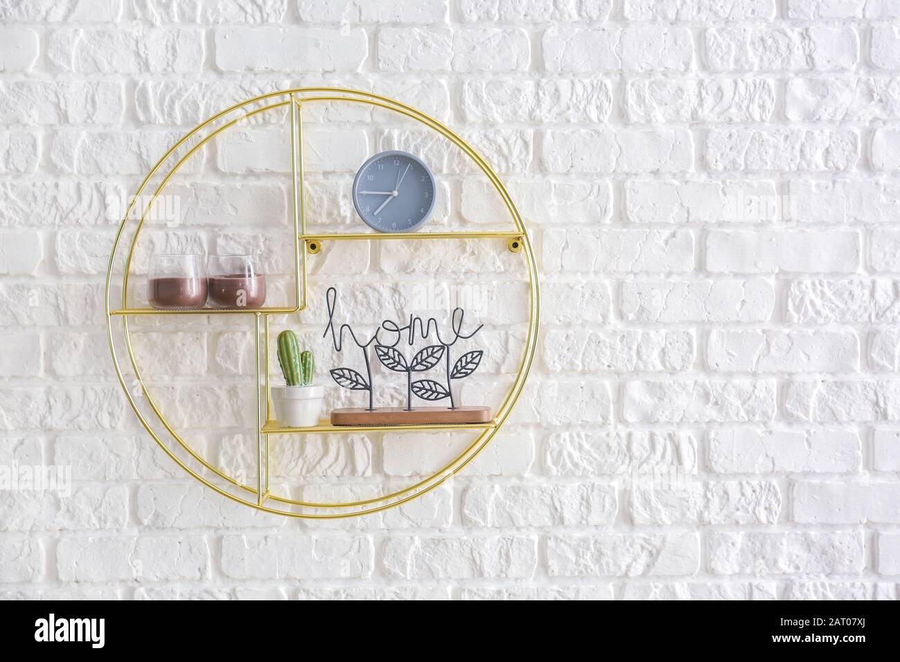 Shelf with decor hanging on white brick wall Stock Photo - Alamy