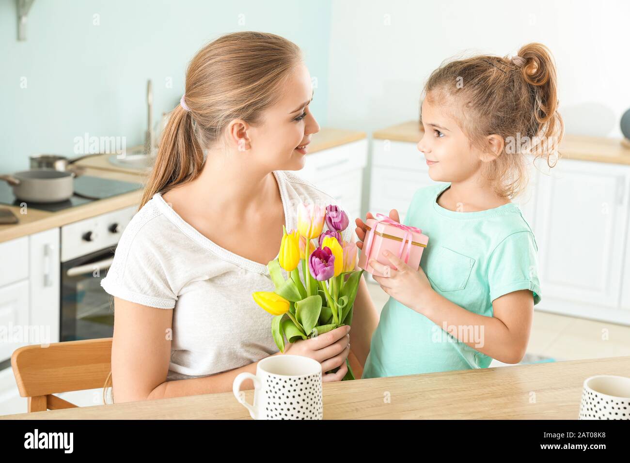 Little girl greeting her mother at home Stock Photo - Alamy
