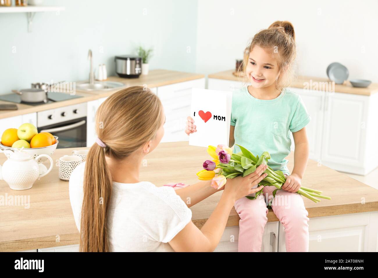 Little girl greeting her mother at home Stock Photo - Alamy