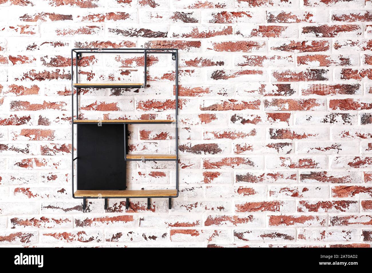Empty shelf hanging on brick wall Stock Photo - Alamy