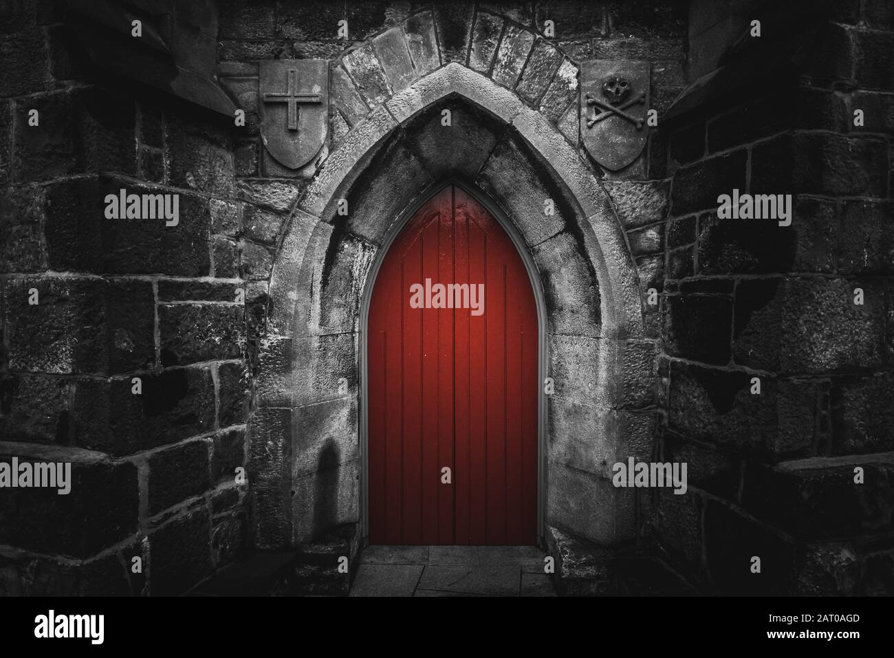 Scary pointy red wooden door in an old and wet stone wall building with ...