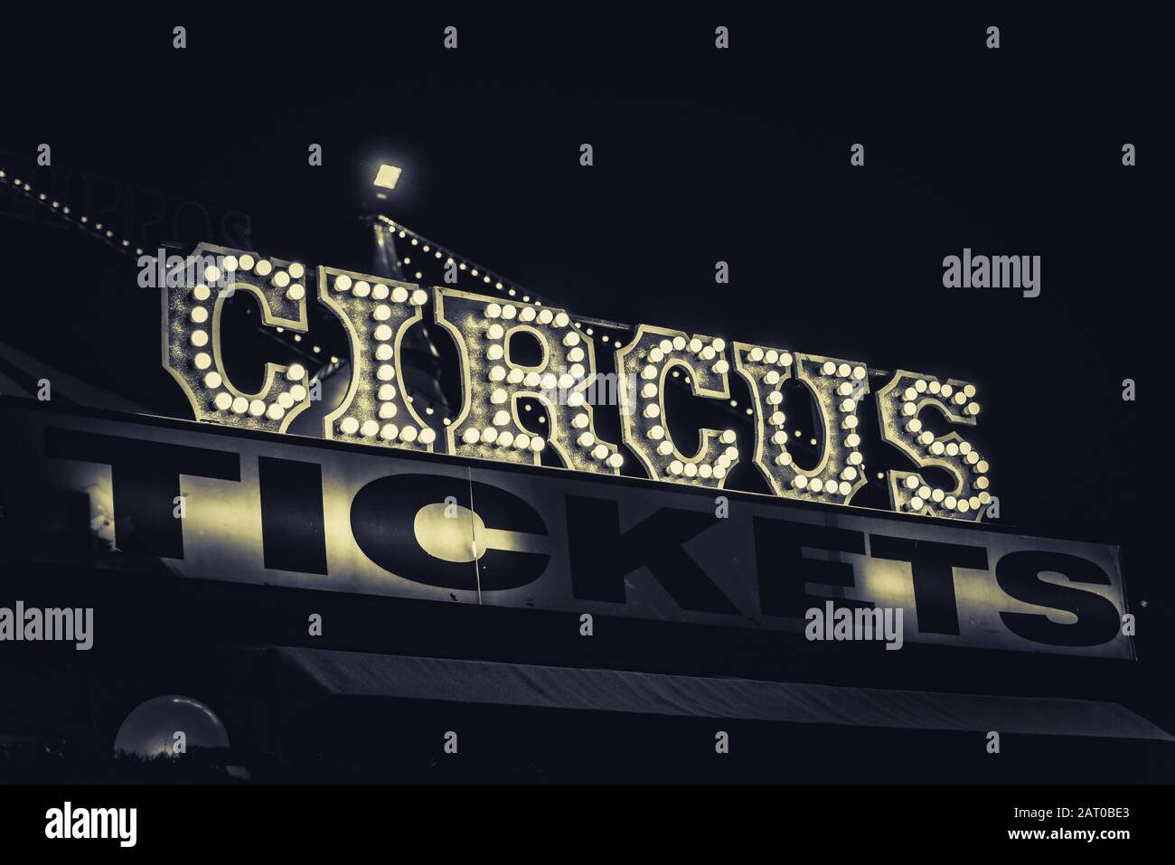 Spooky old dimly lit circus sign with light bulbs in the dark over a ...