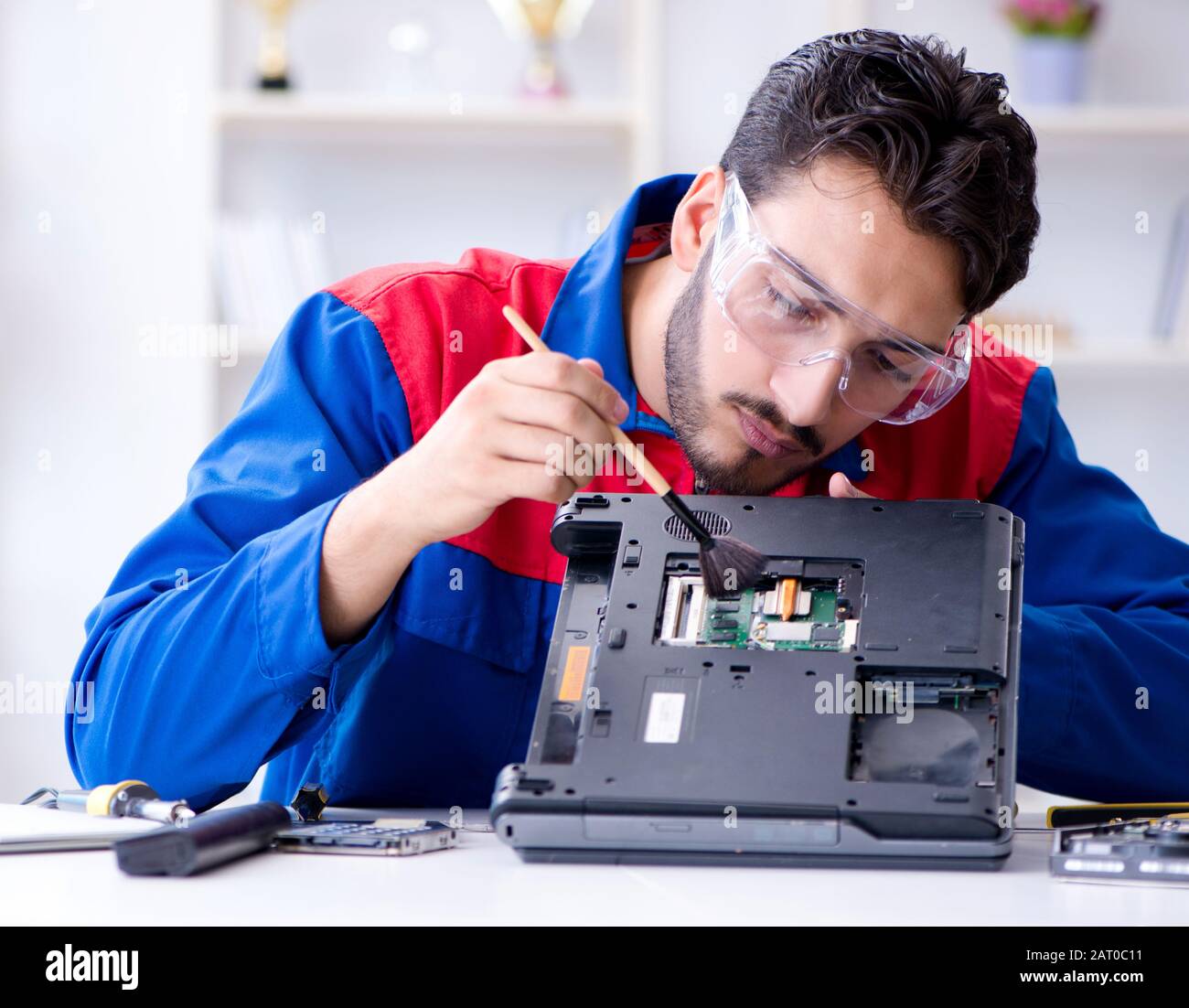 Repairman working in technical support fixing computer laptop ...