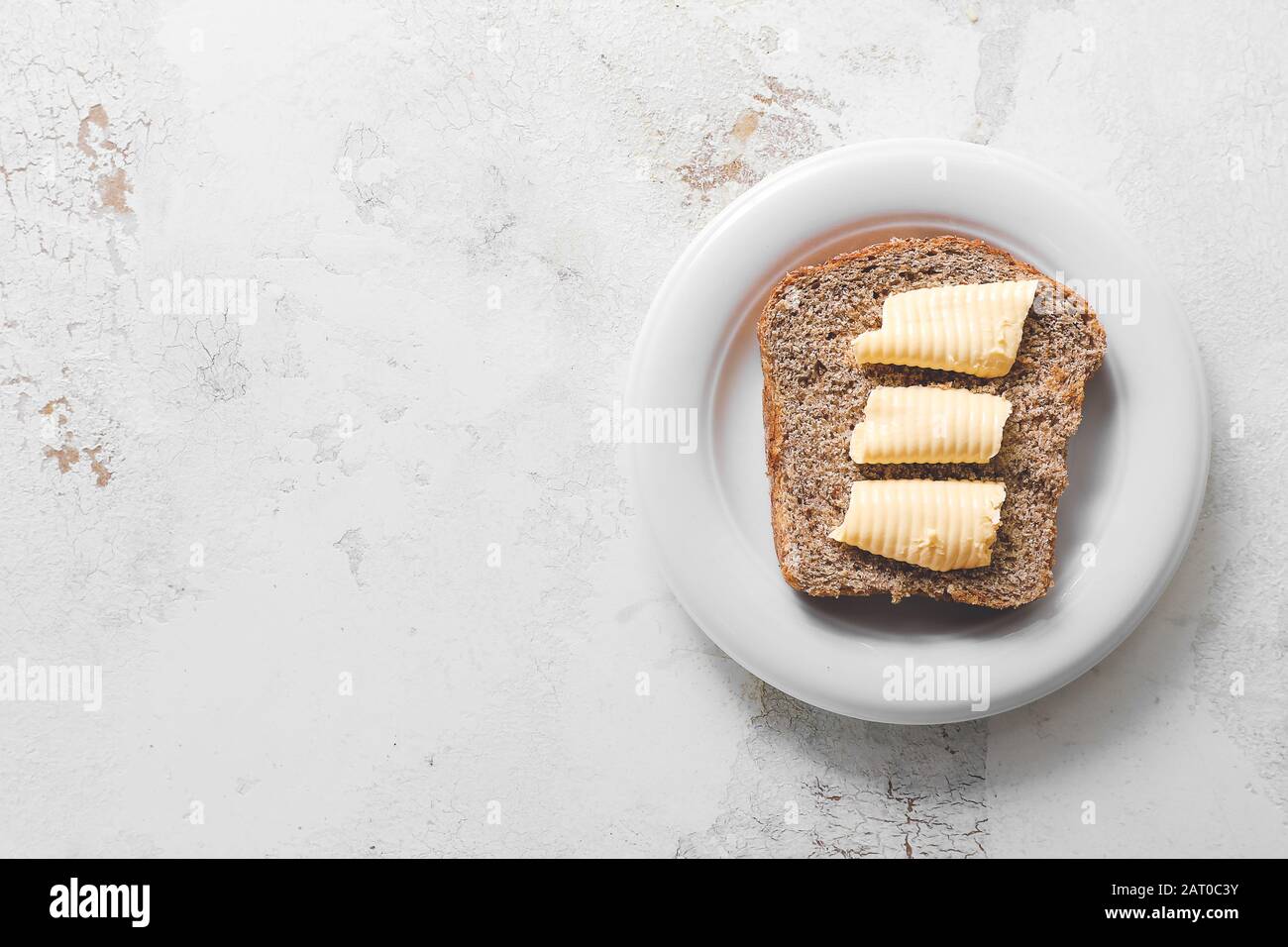 Plate with tasty bread and butter on white background Stock Photo - Alamy