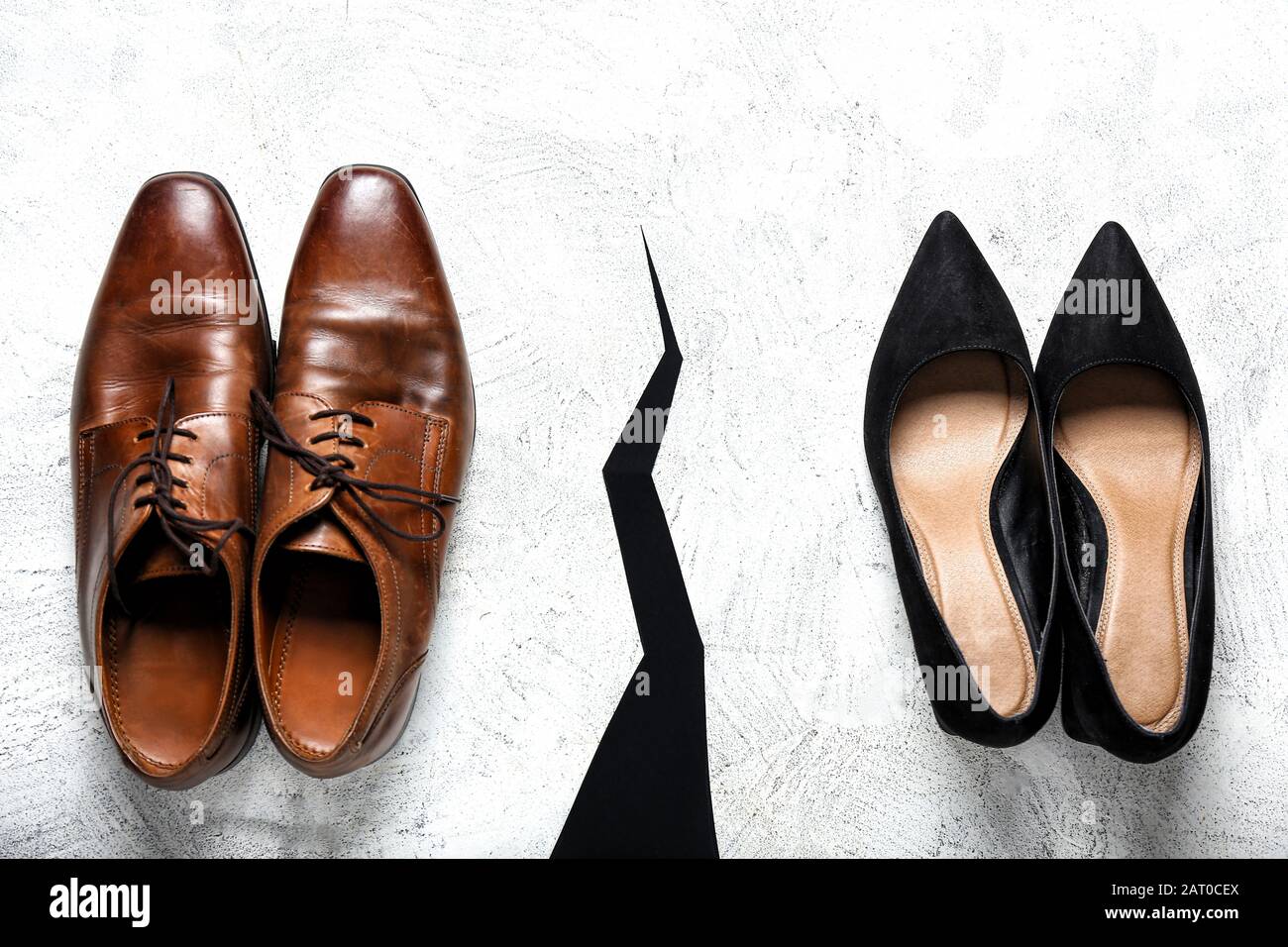 Crack between two pairs of shoes on light background. Concept of ...