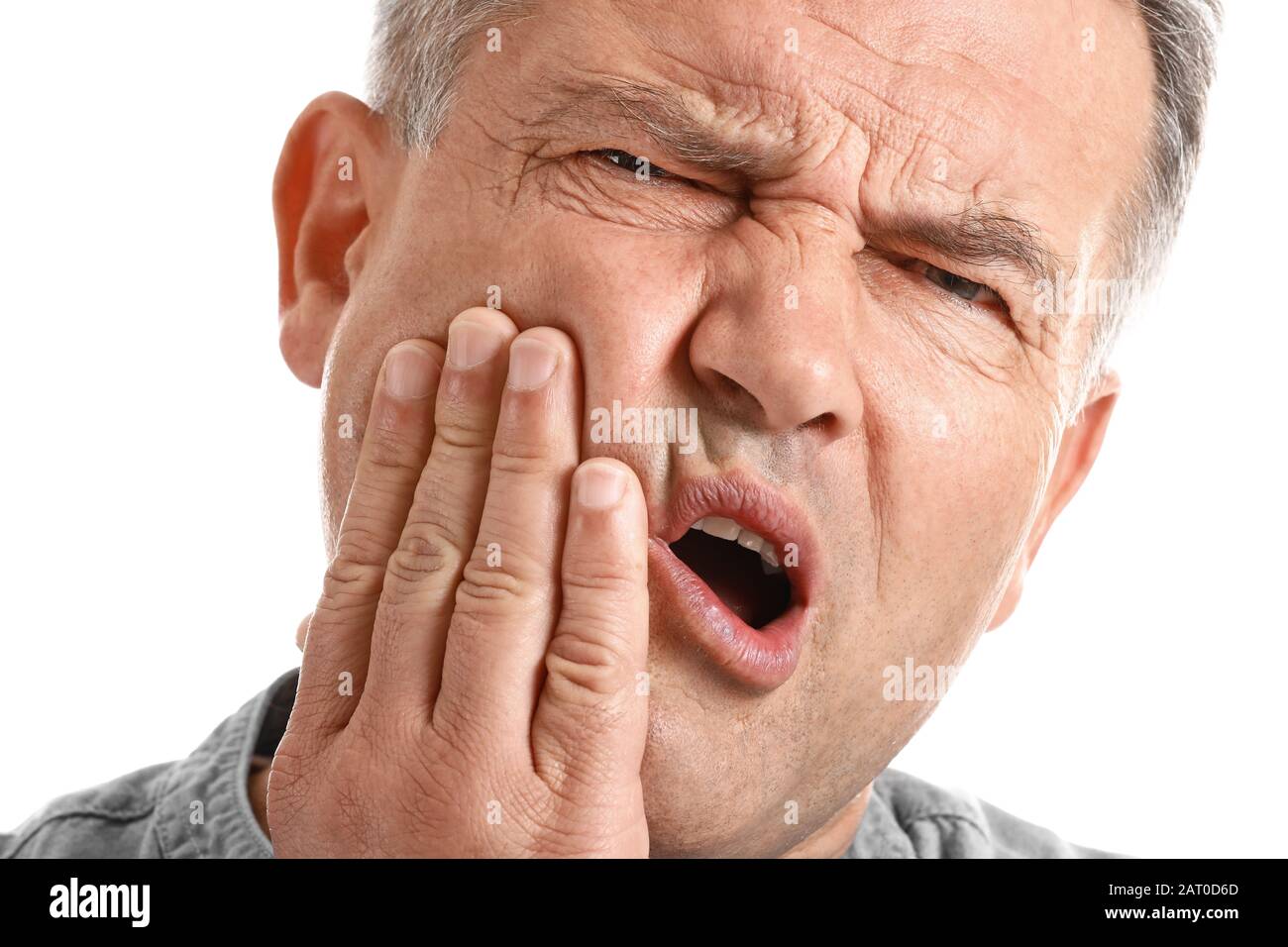 Mature man suffering from tooth pain on white background, closeup Stock ...