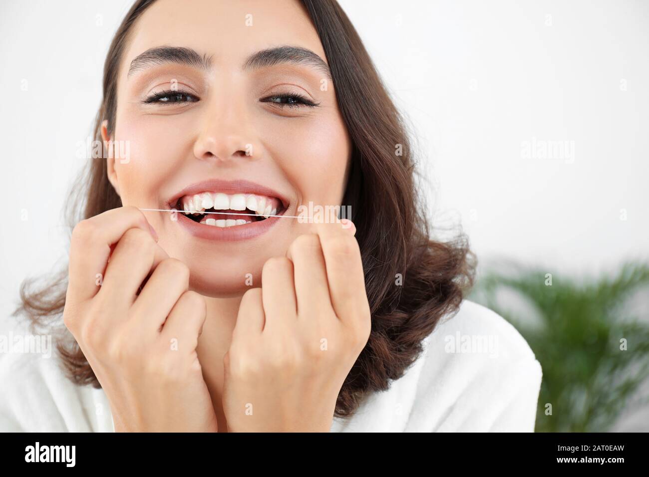 Beautiful young woman with dental floss in bathroom Stock Photo - Alamy