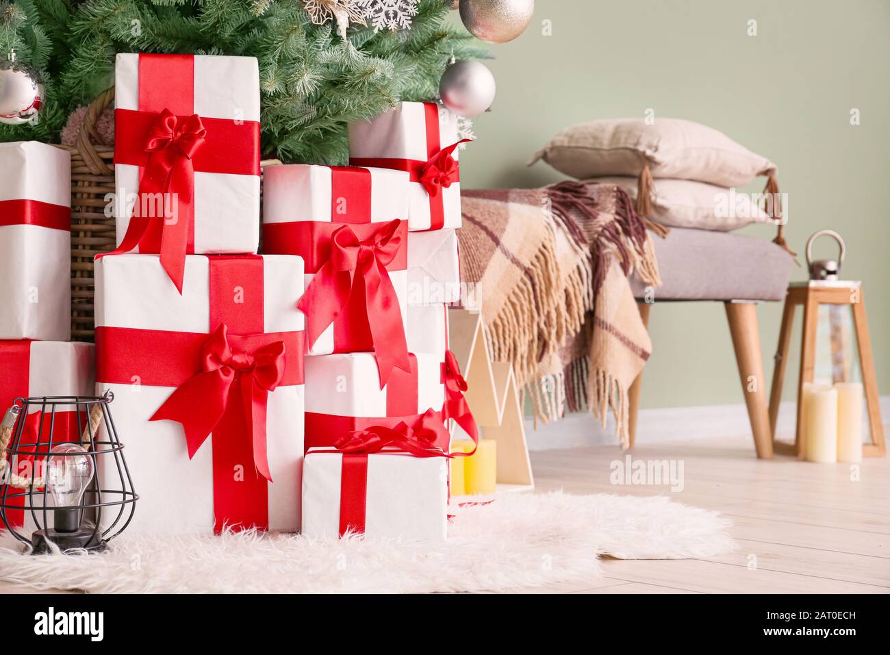 Gift boxes under Christmas tree in room Stock Photo - Alamy
