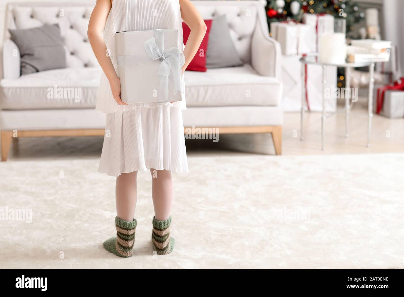 Little girl with Christmas present behind her back at home Stock Photo ...