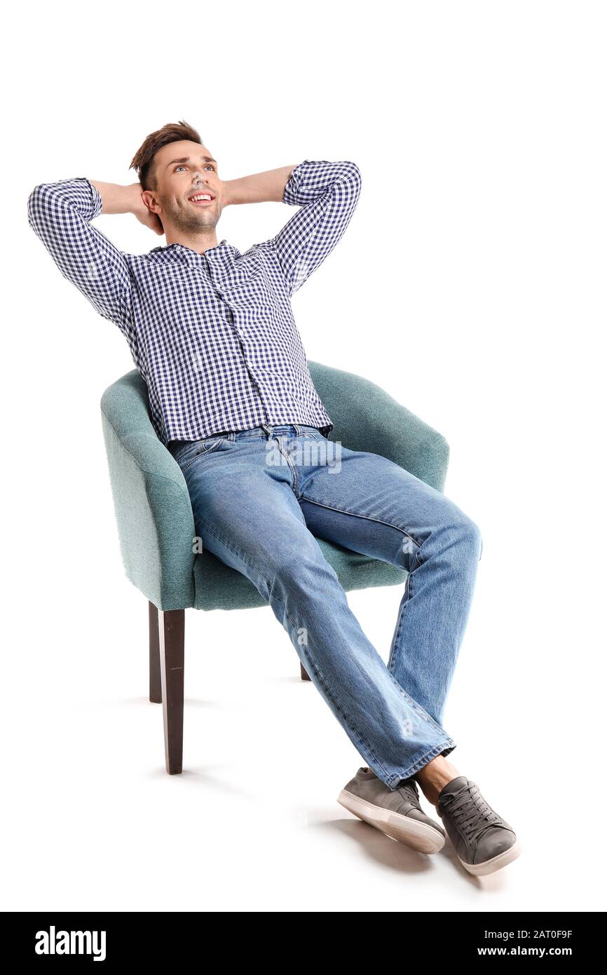 Handsome man sitting in armchair on white background Stock Photo - Alamy