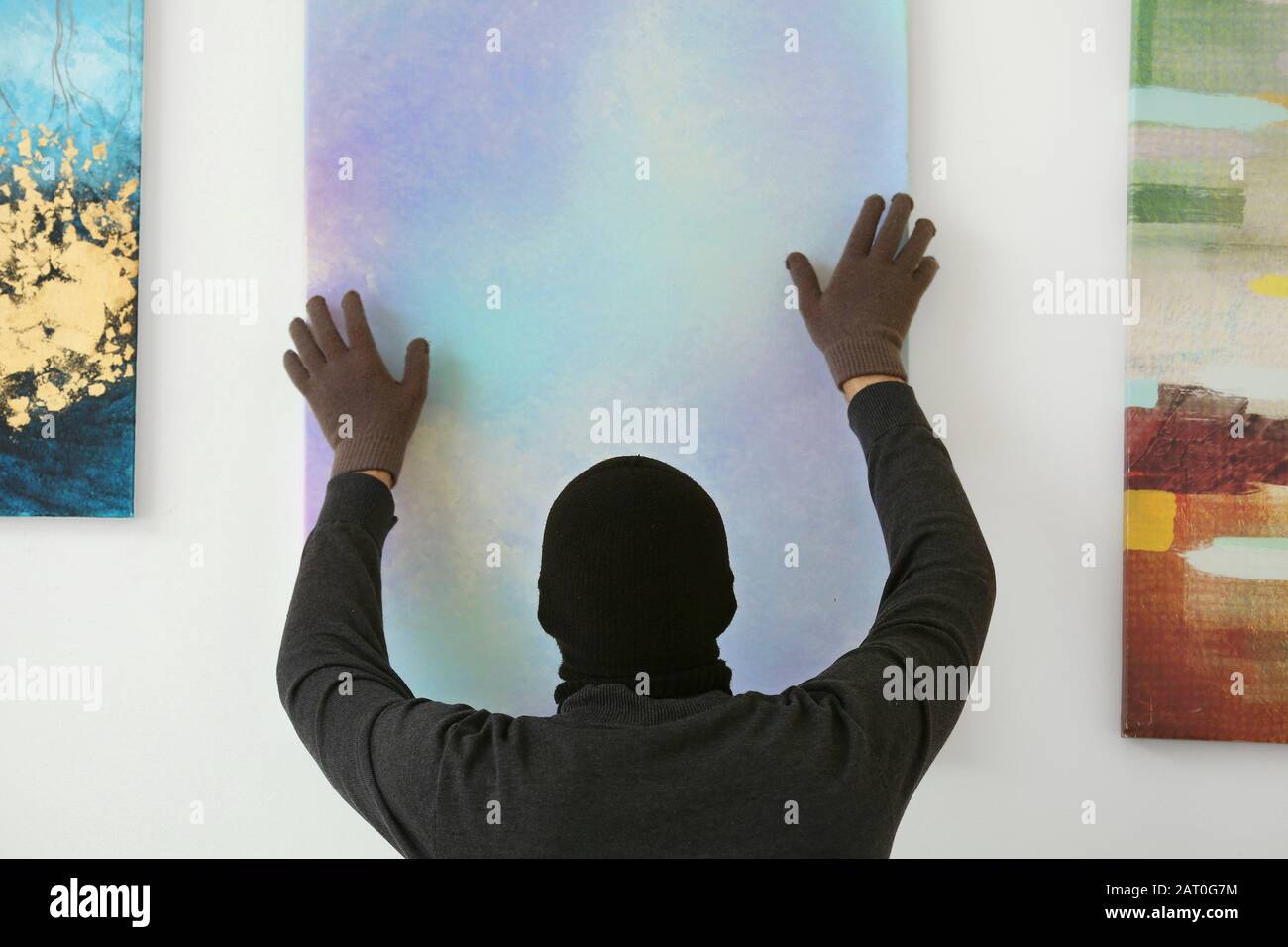 Thief stealing picture from art gallery Stock Photo - Alamy