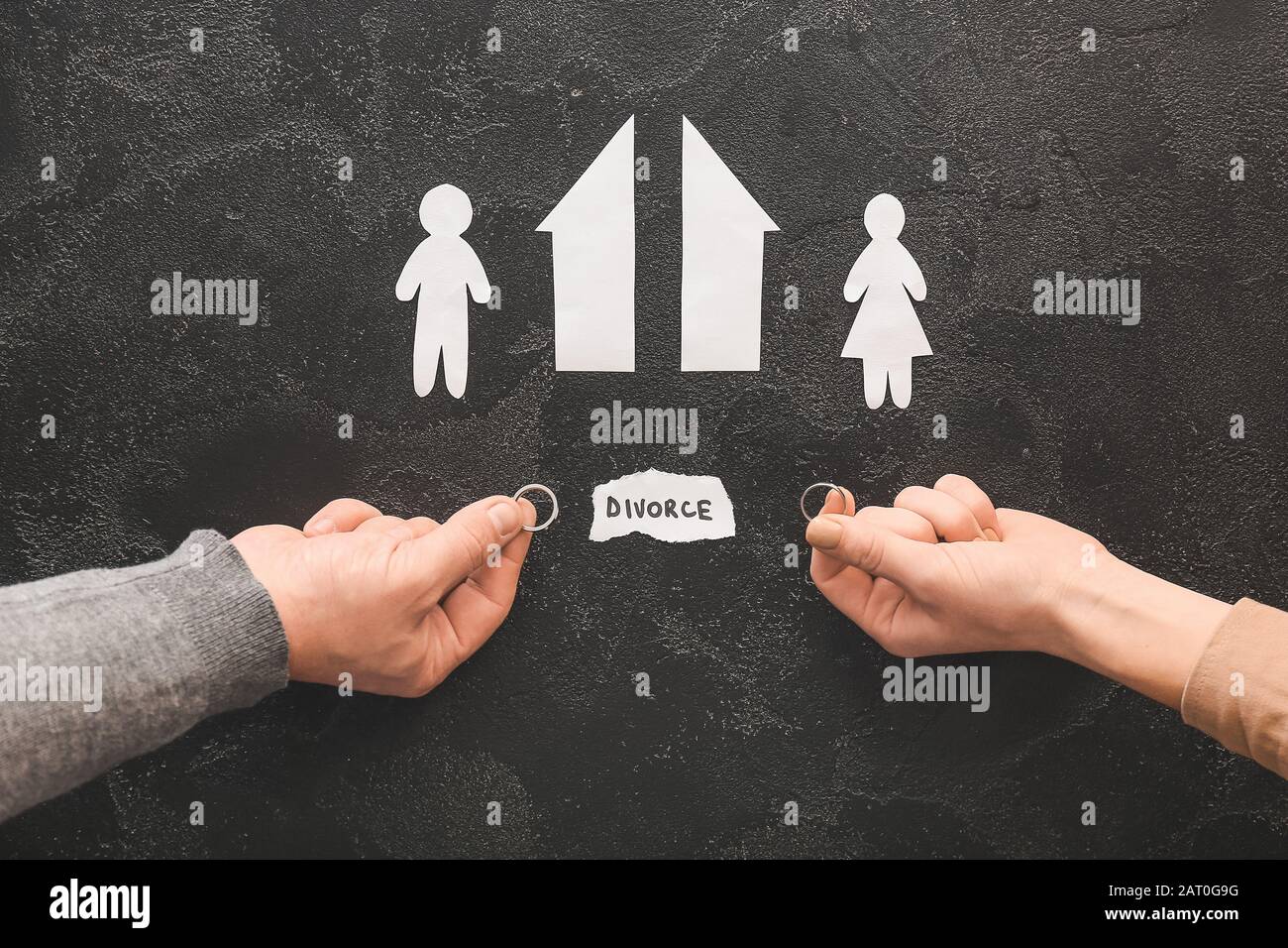 Male and female hands with wedding rings, cut figures of house and ...