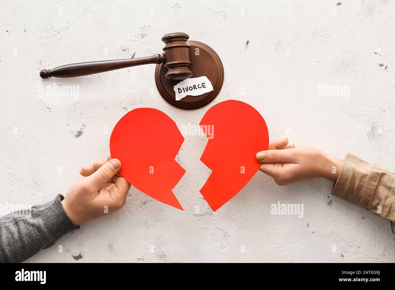 Hands of couple with broken heart and judge's gavel on white background ...