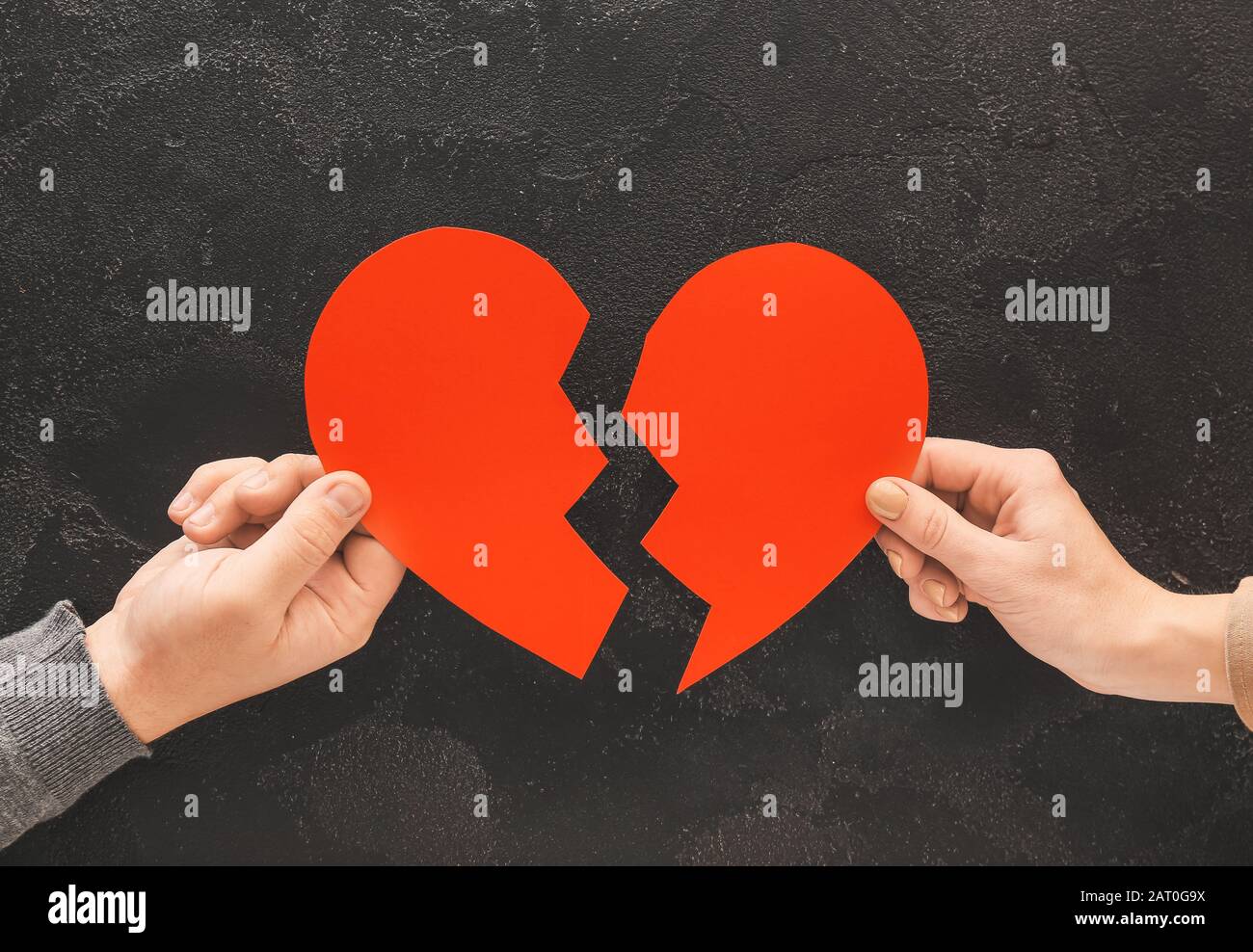 Hands of couple with broken heart on dark background. Concept of ...