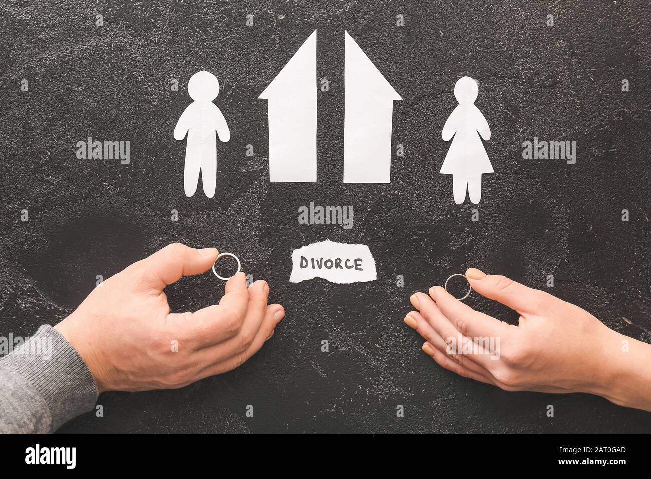 Male and female hands with wedding rings, cut figures of house and ...