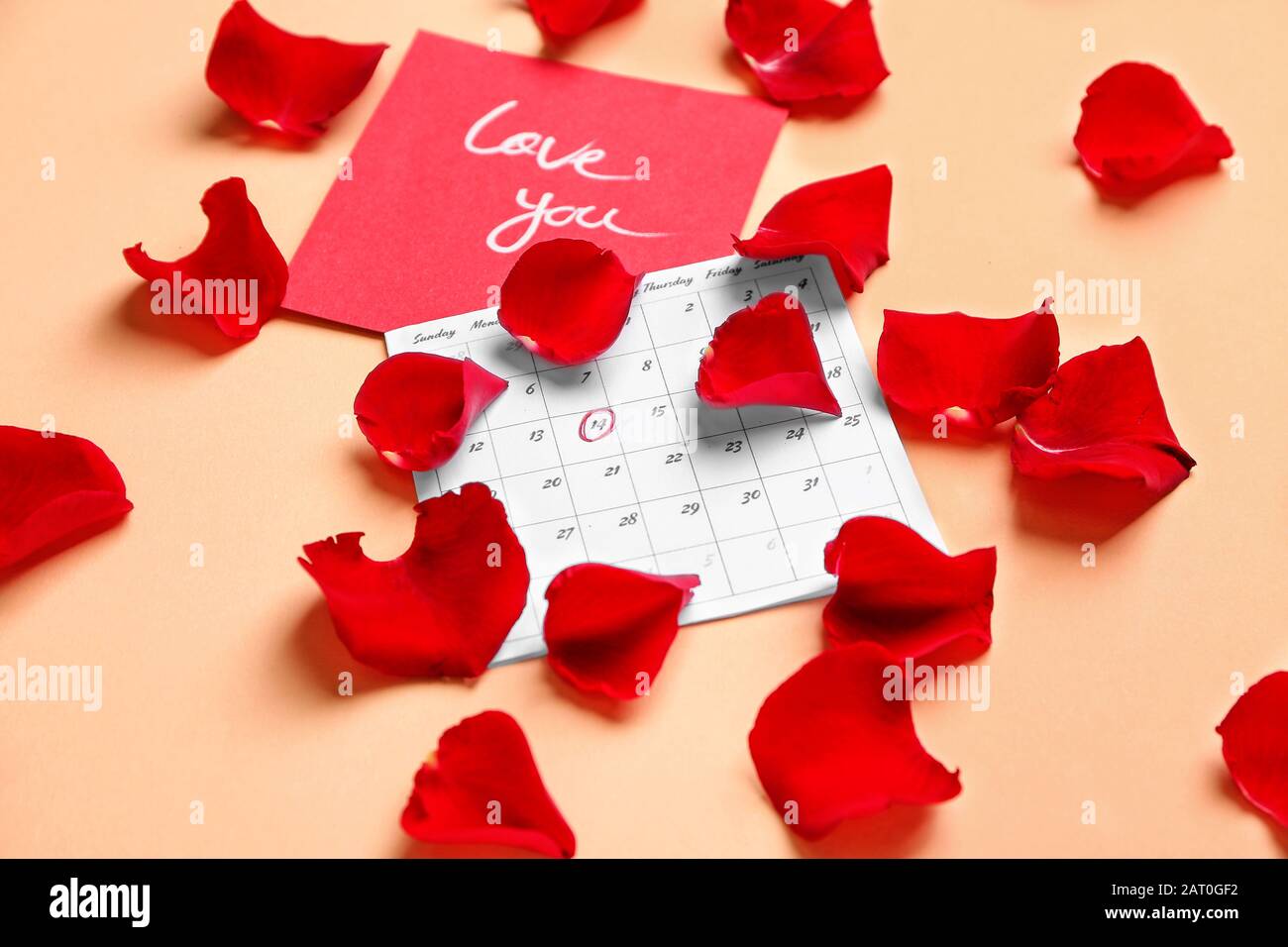 Calendar with marked date of Valentine's Day, card and rose petals on ...
