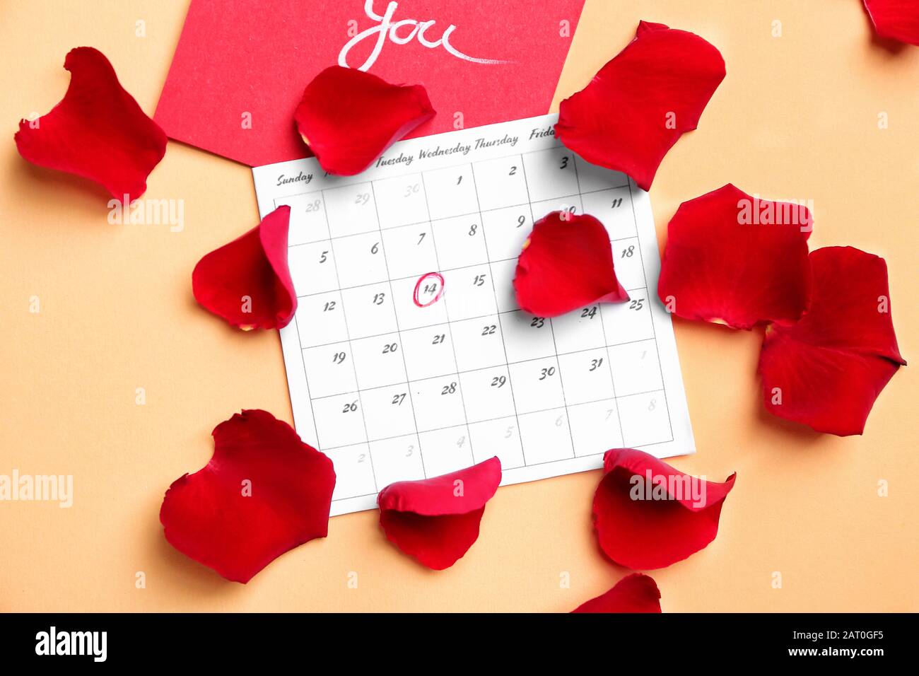 Calendar with marked date of Valentine's Day, card and rose petals on ...