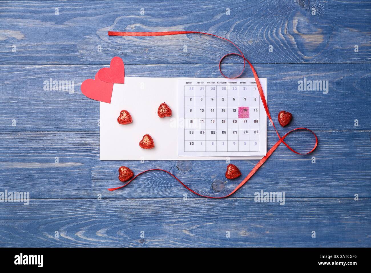 Calendar with marked date of Valentine's Day and hearts on wooden ...