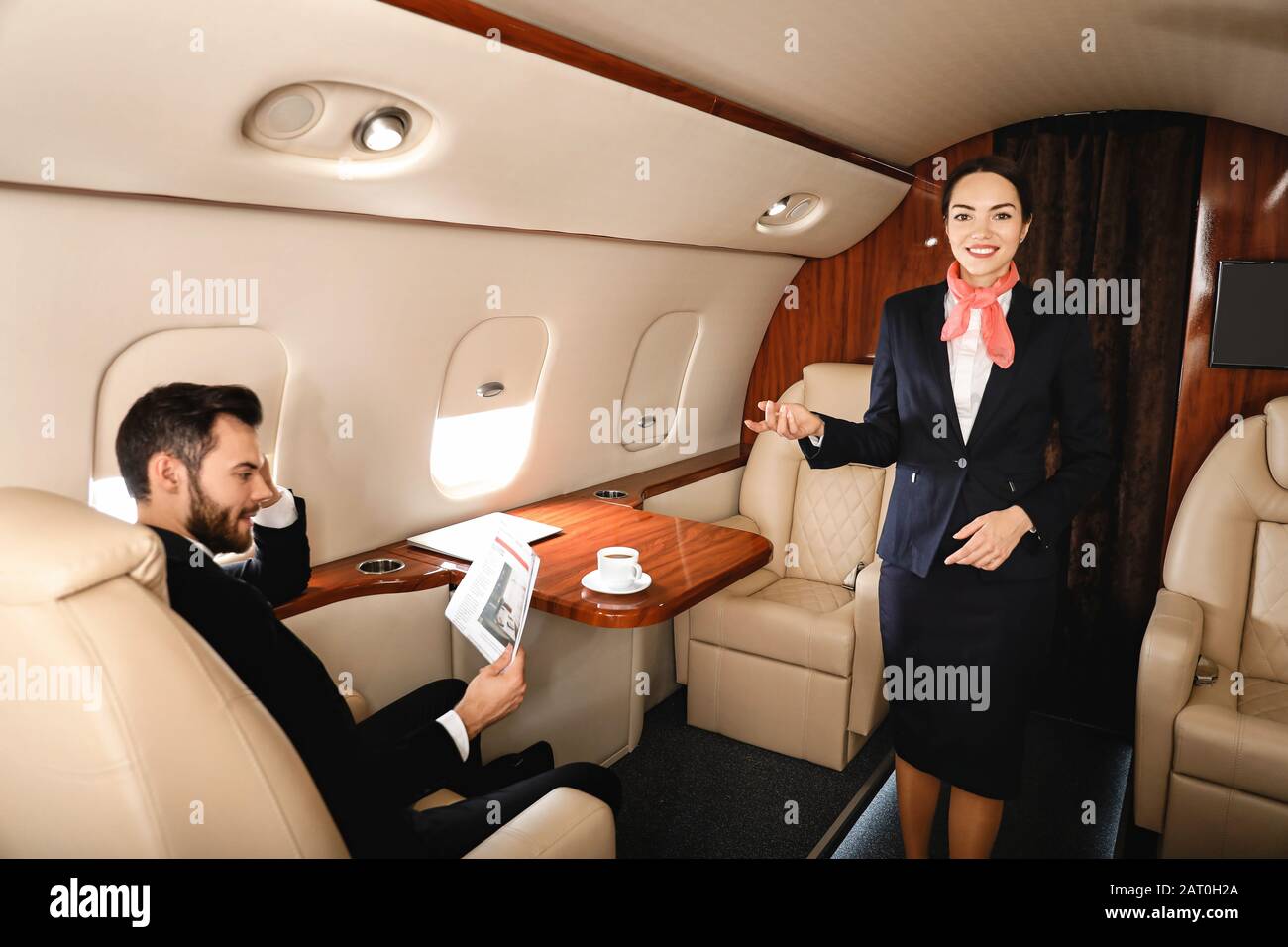 Air hostess and businessman on board the modern private airplane Stock ...