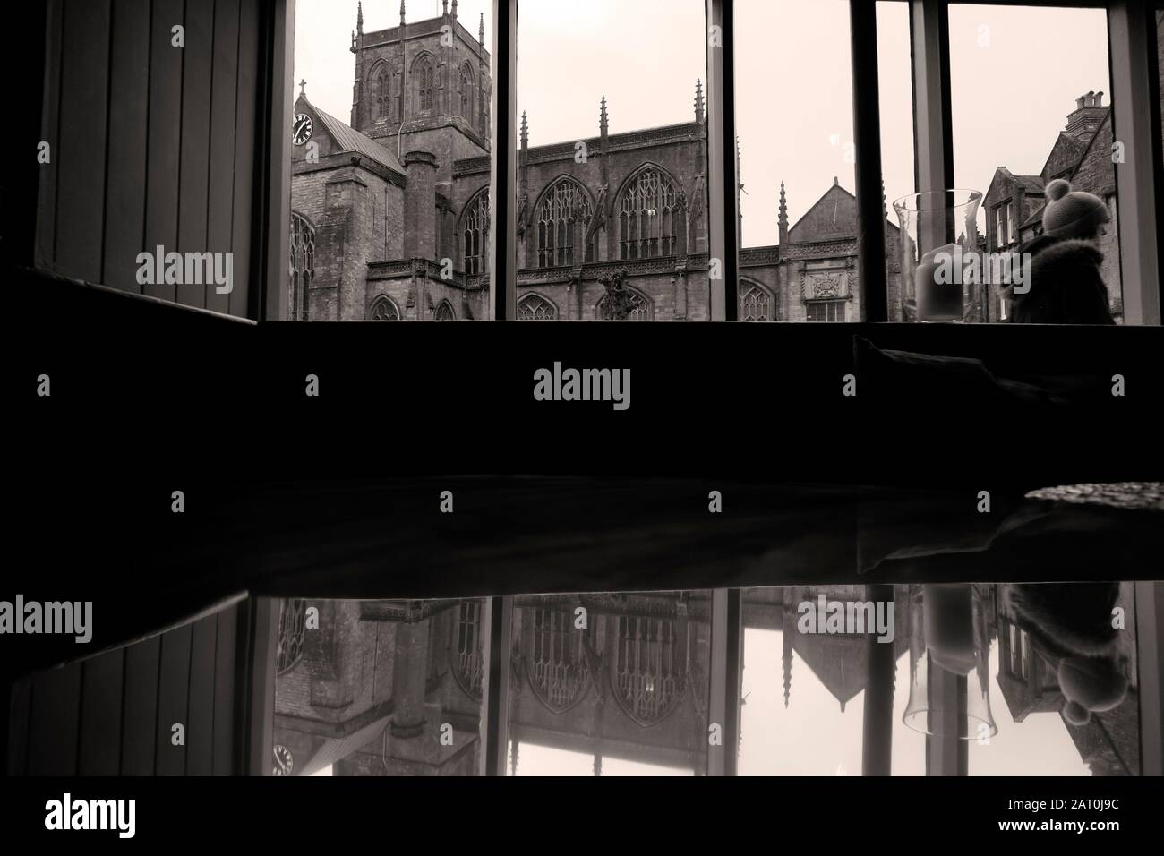 Sherborne Abbey through pub window reflected in copper topped table ...