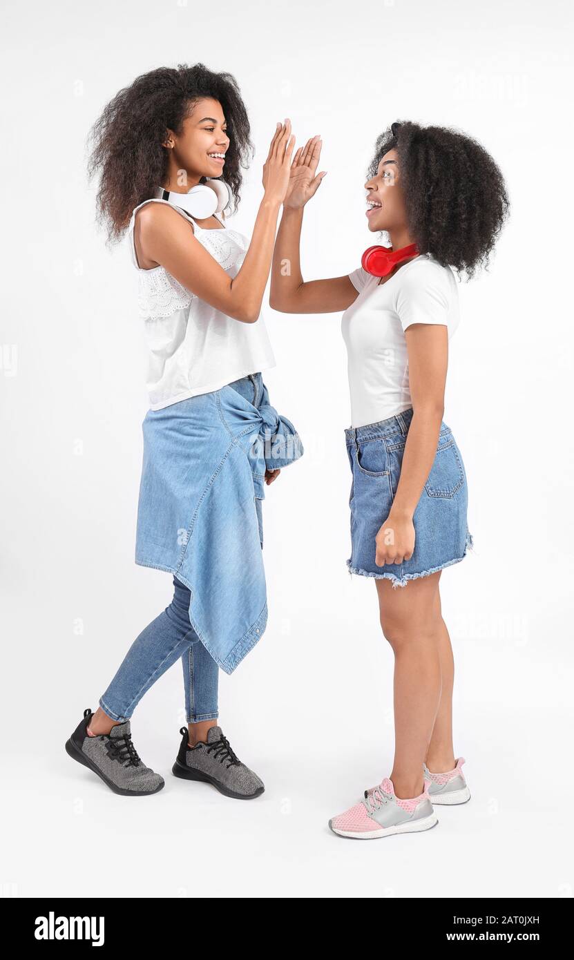 Portrait of young African-American women giving each other high-five on ...