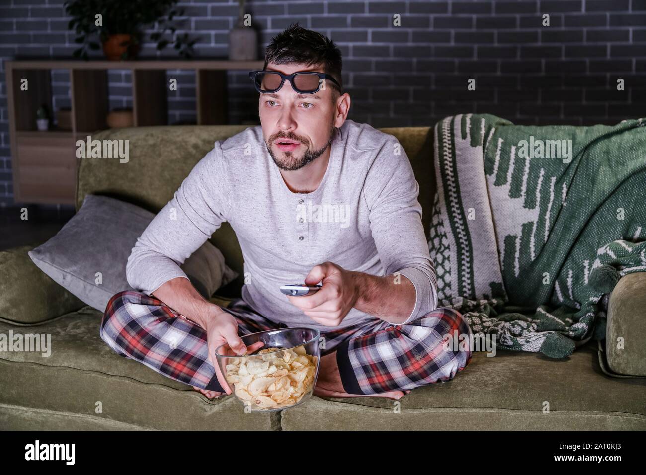 Man watching movie late in evening at home Stock Photo - Alamy