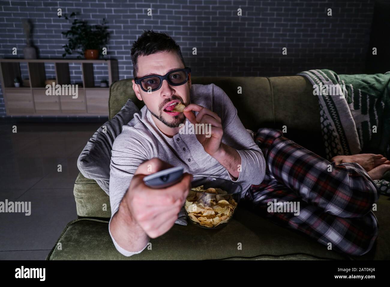 Man watching movie late in evening at home Stock Photo - Alamy