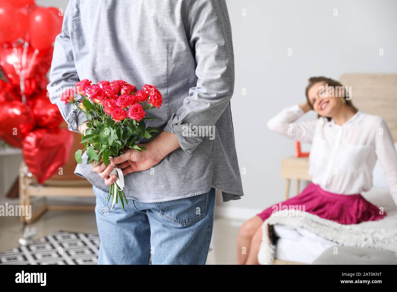 Man hiding bouquet of flowers for his girlfriend behind back. Valentine ...