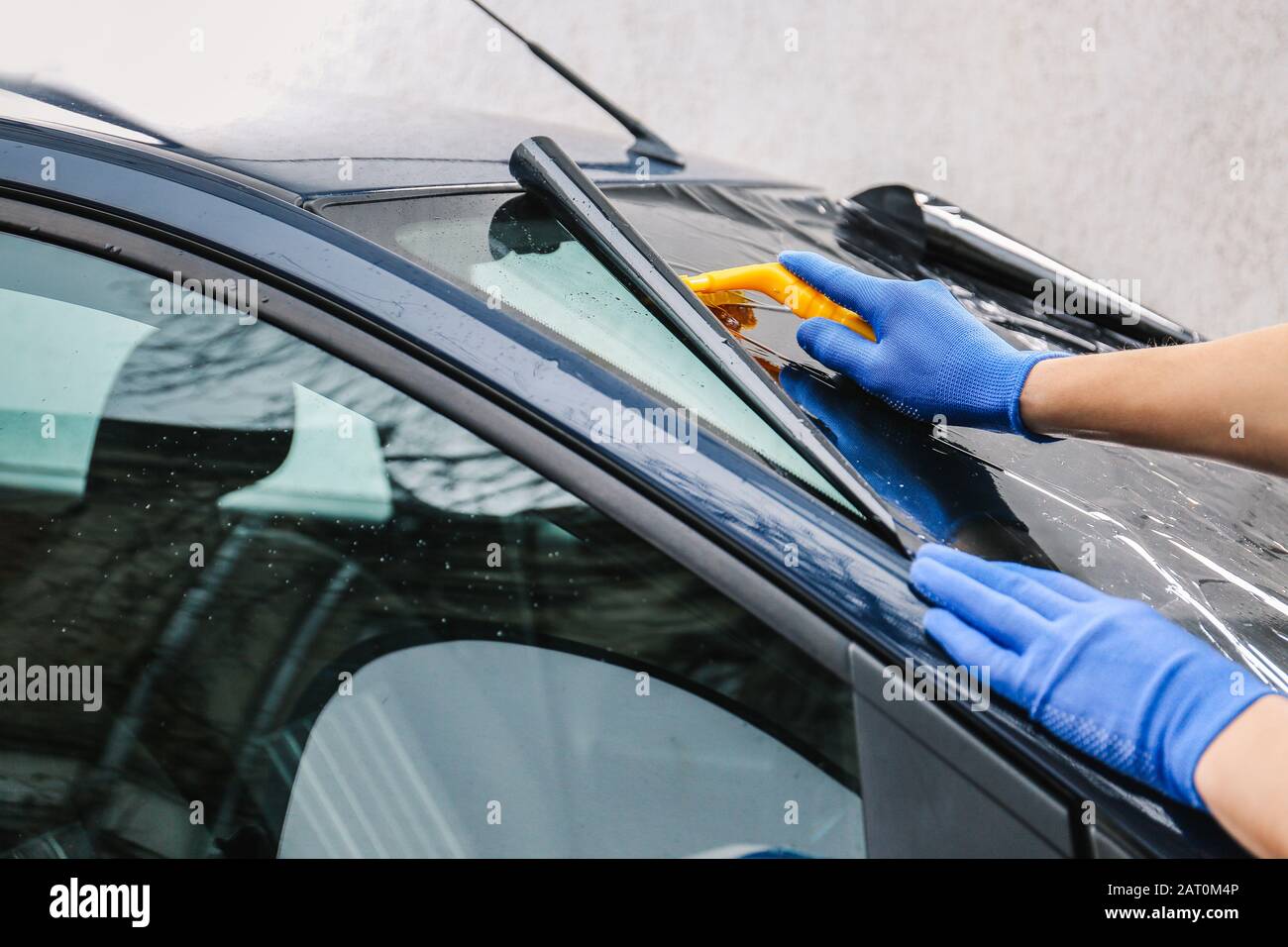 Male worker tinting car window Stock Photo - Alamy