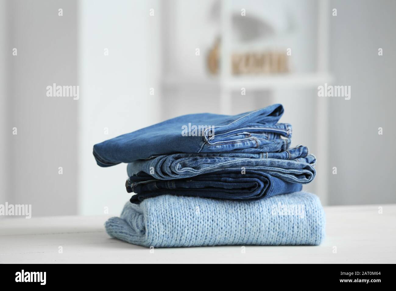 Stack of clean clothes on table in room Stock Photo - Alamy