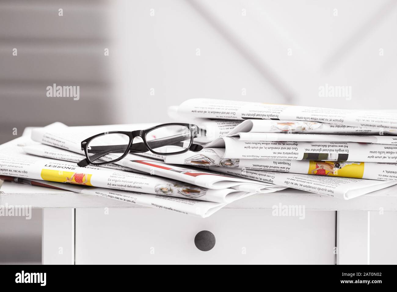 Stack of newspapers on table in room Stock Photo - Alamy