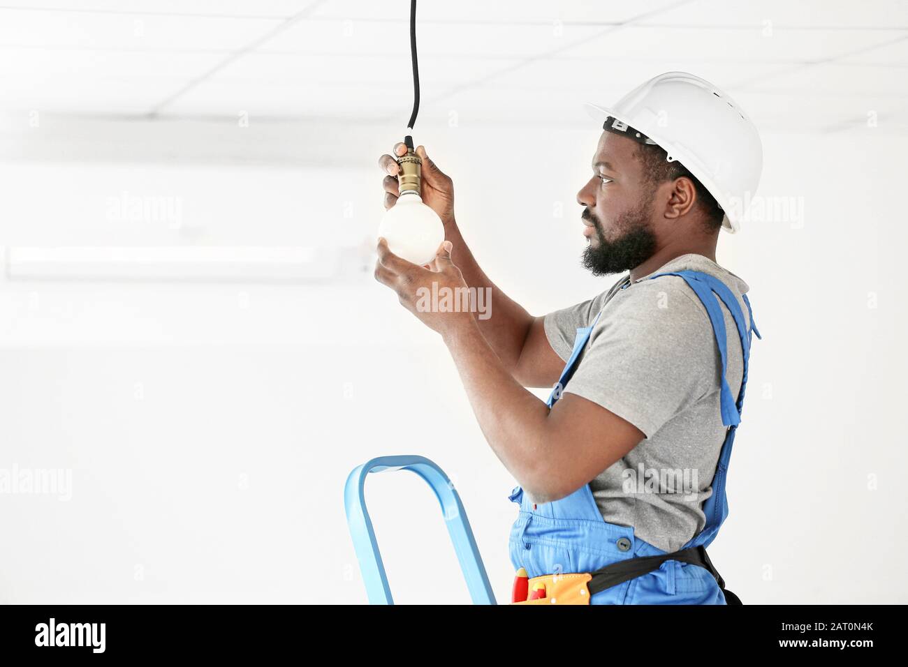African-American electrician performing wiring in room Stock Photo - Alamy