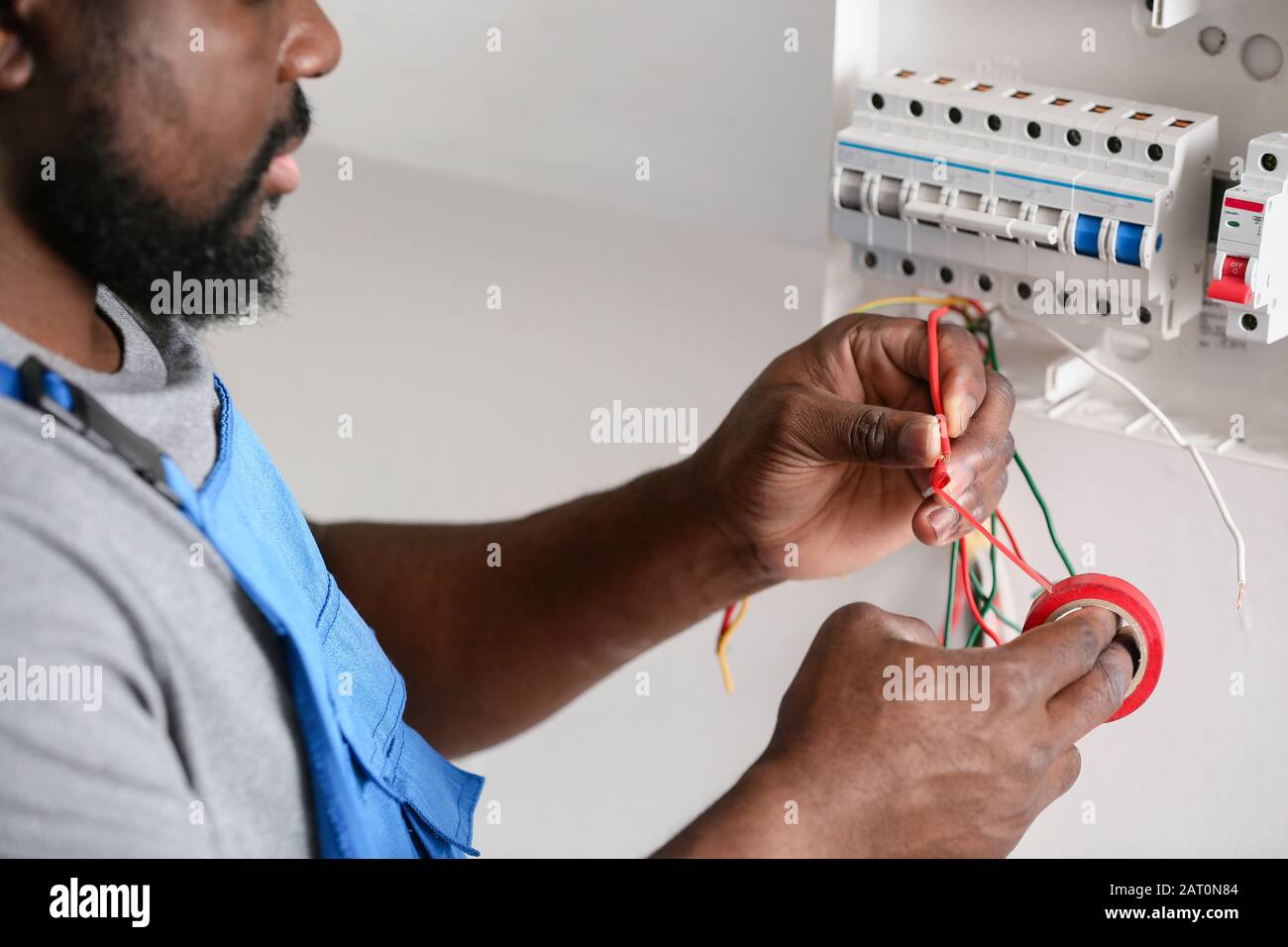 African-American electrician performing wiring in room Stock Photo - Alamy