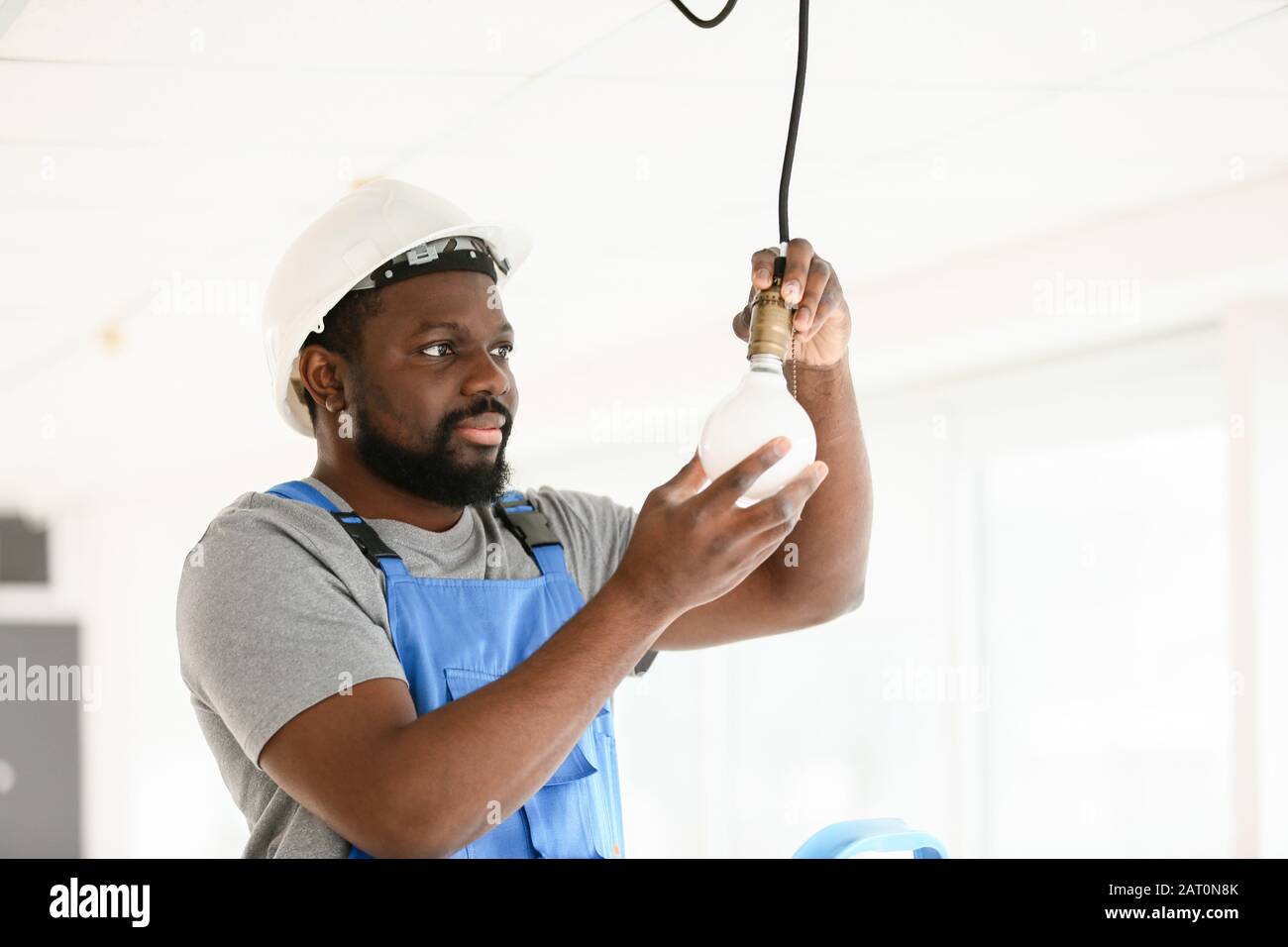 African-American electrician performing wiring in room Stock Photo - Alamy