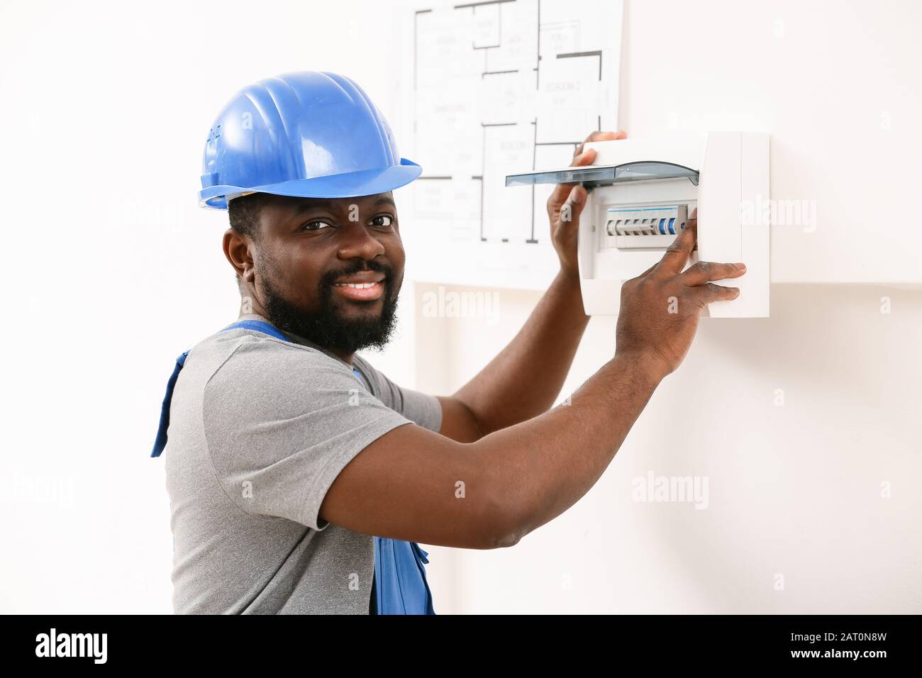 African-American electrician performing wiring in room Stock Photo - Alamy