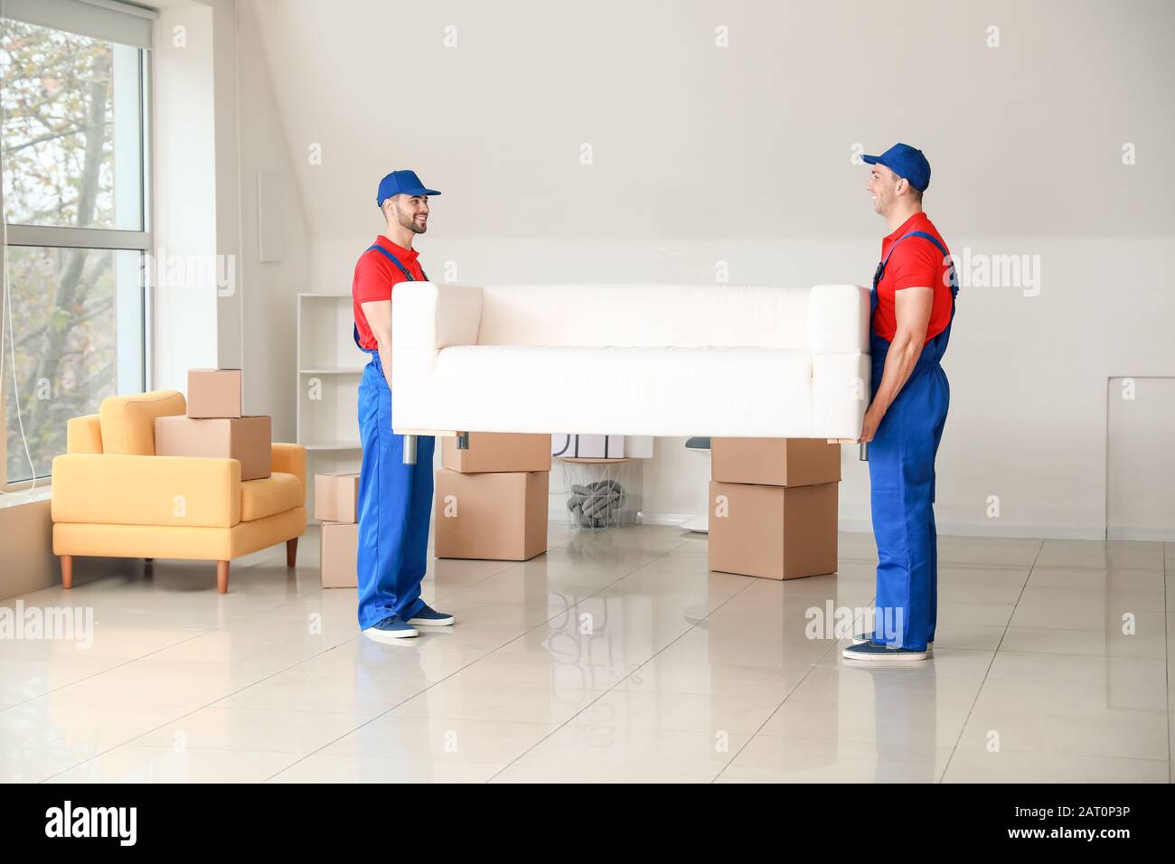 Loaders carrying furniture on moving day Stock Photo - Alamy