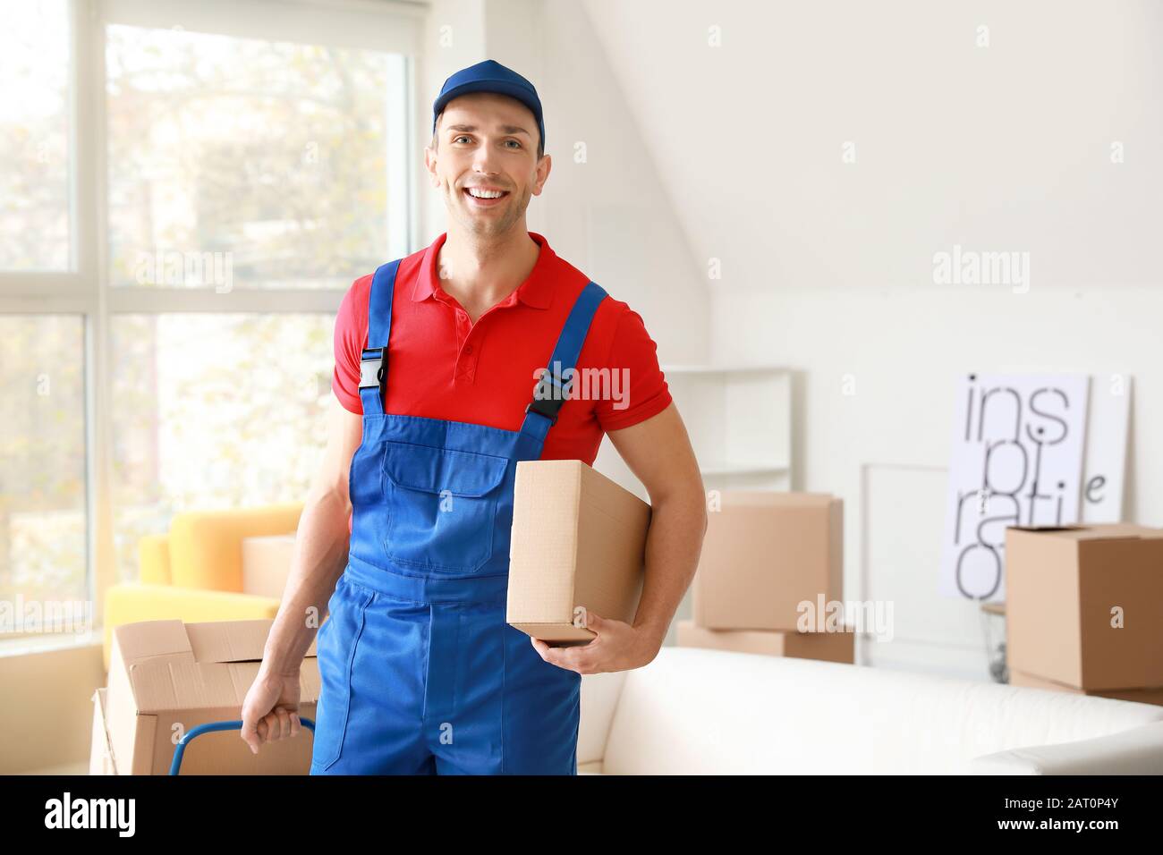 Delivery man with boxes in room Stock Photo - Alamy