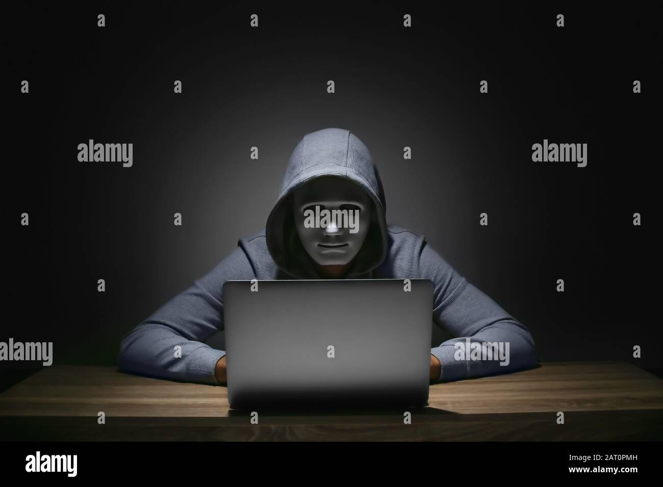 Professional hacker using laptop at table against dark background Stock ...