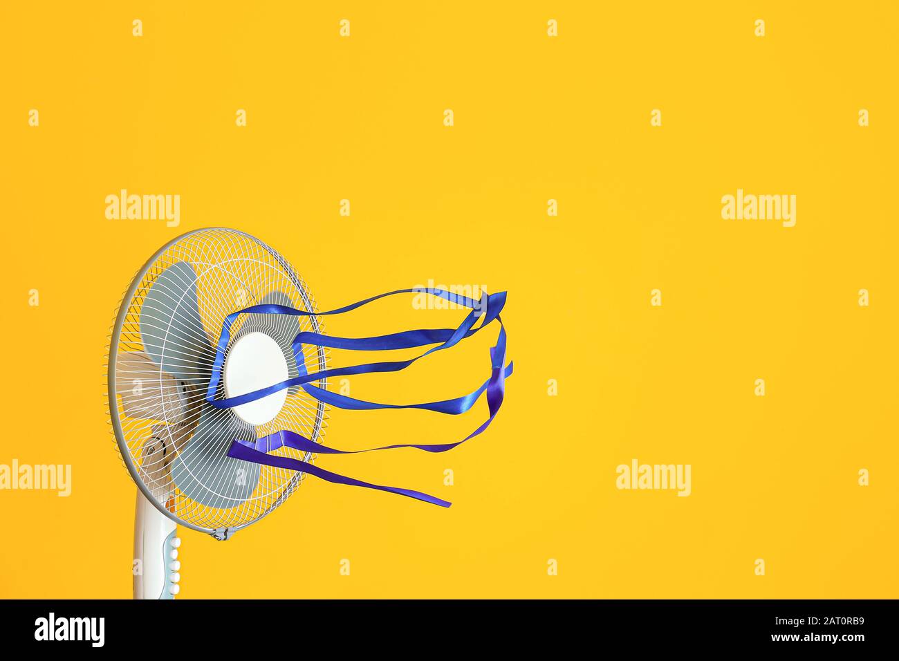 Electric fan with fluttering ribbons on color background Stock Photo ...