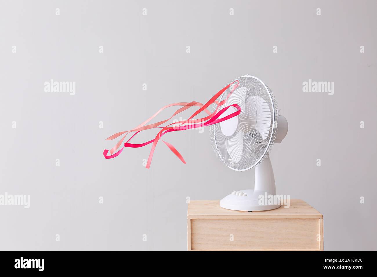 Electric fan with fluttering ribbons on light background Stock Photo ...