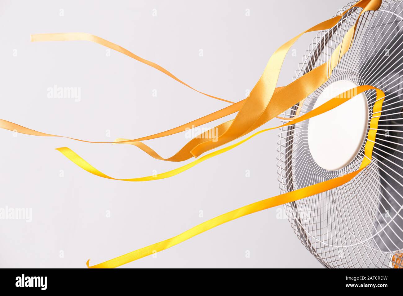 Electric fan with fluttering ribbons on light background Stock Photo ...