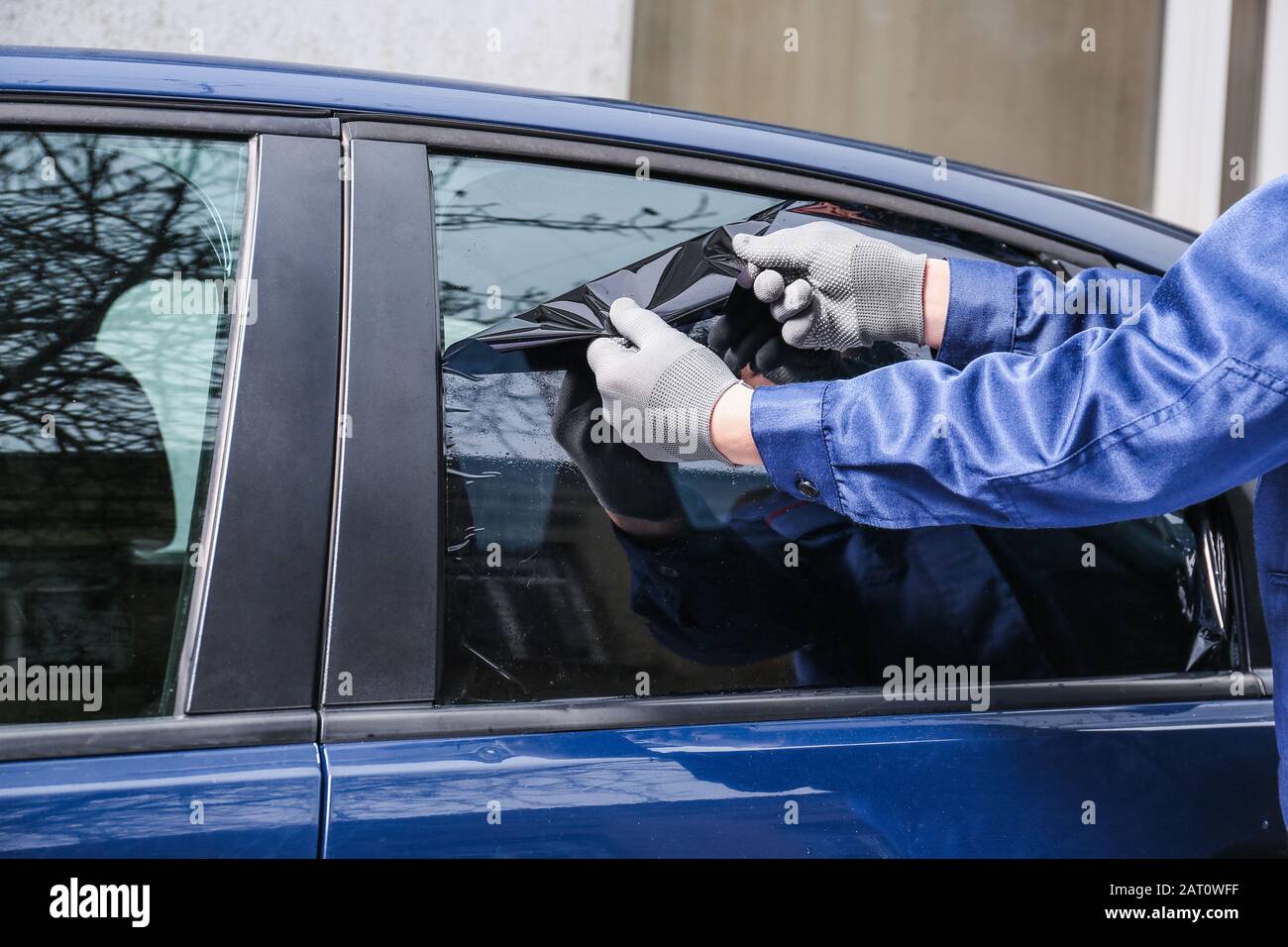 Male worker tinting car window Stock Photo - Alamy