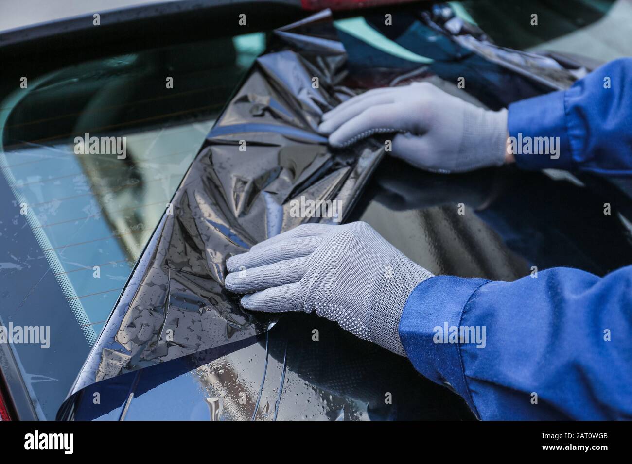 Male worker tinting car window Stock Photo - Alamy