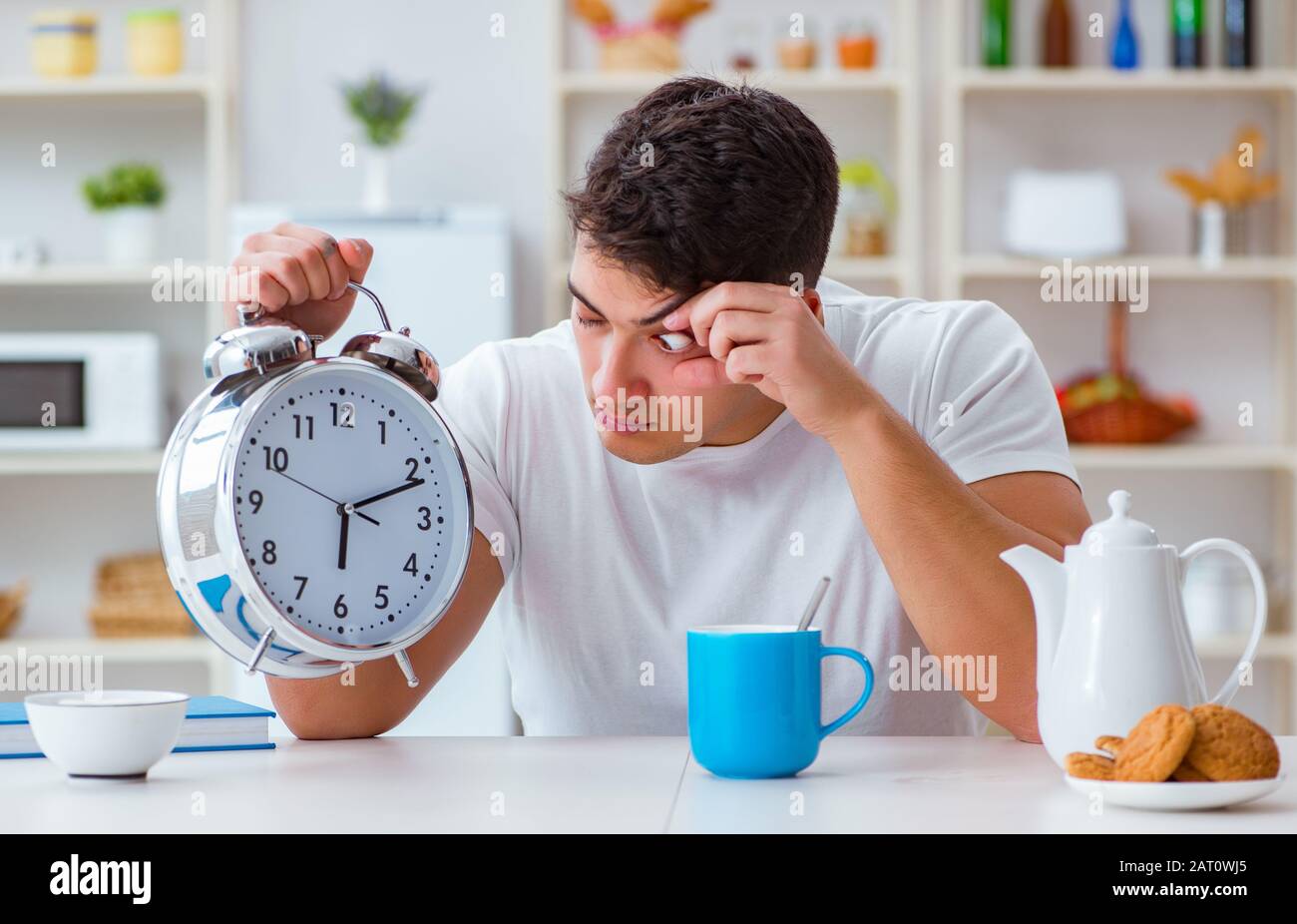 The man with alarm clock falling asleep at breakfast Stock Photo - Alamy