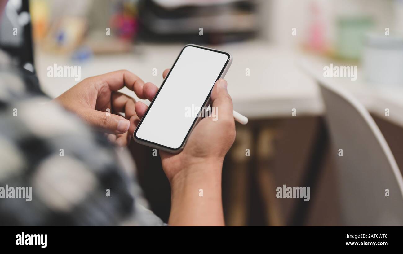 Cropped shot of a man using blank screen smartphone while working in ...