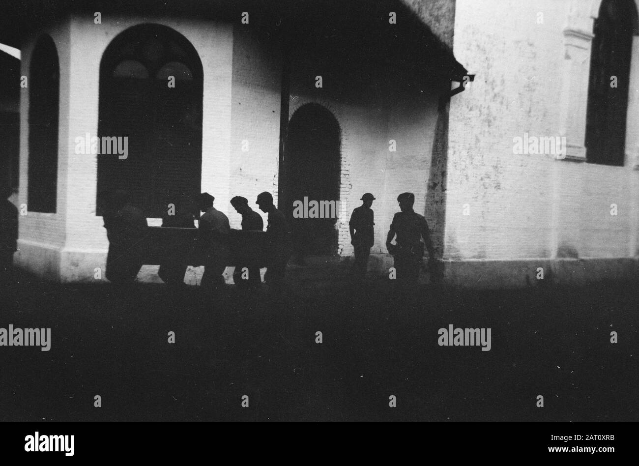 [a military funeral procession leaves a Roman Catholic church ...
