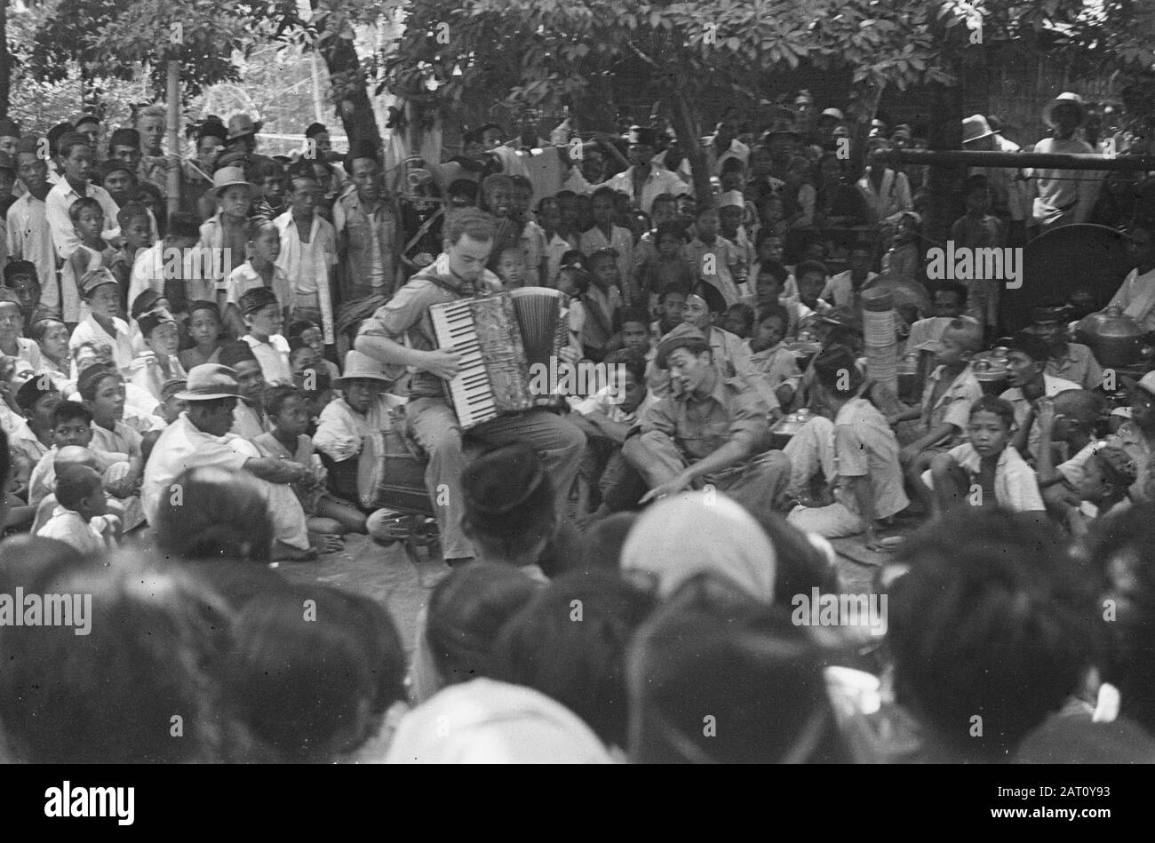 Surabaya A Dutch military plays accordion. Village population listens ...