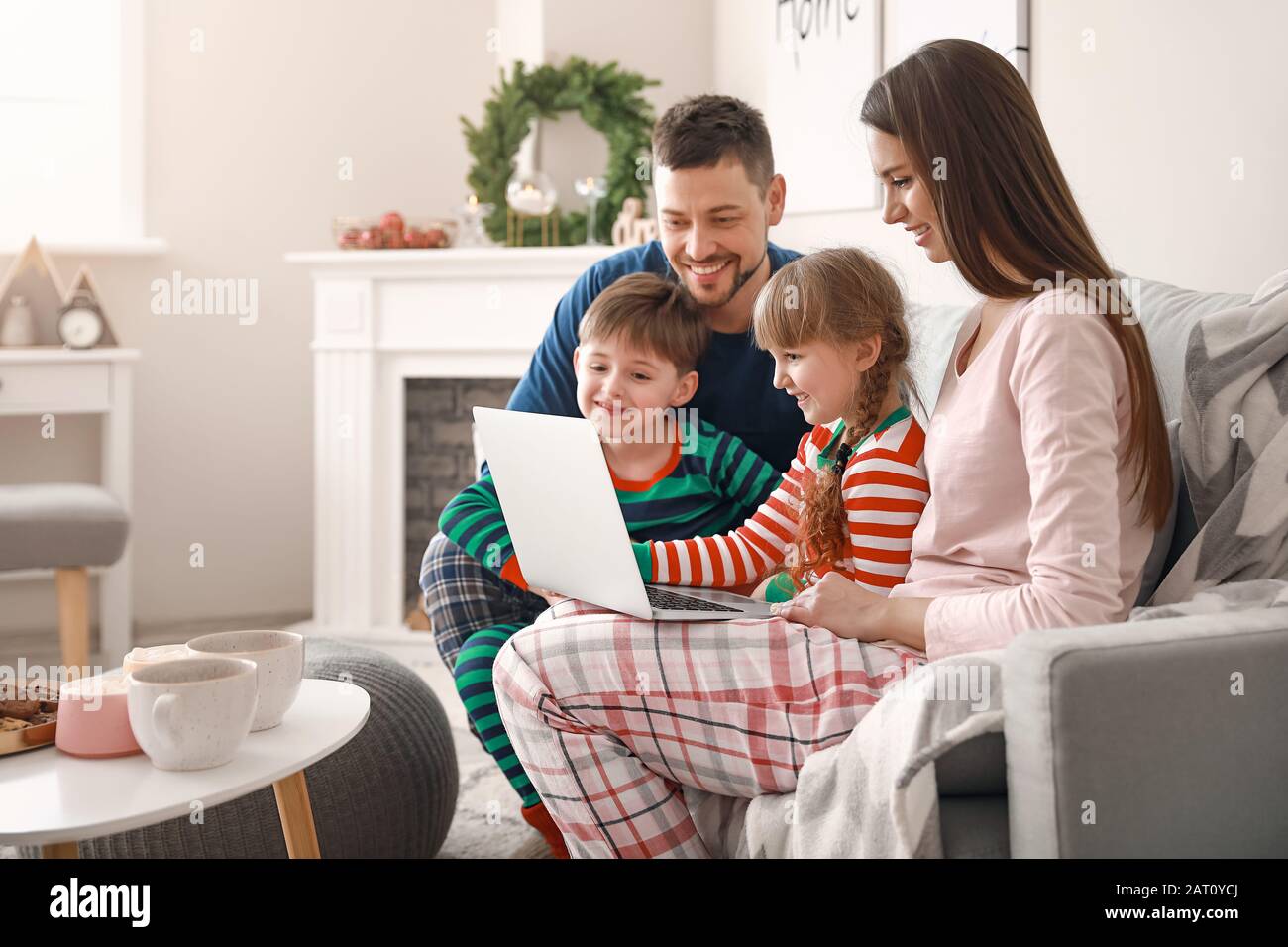 Happy family with laptop resting at home Stock Photo - Alamy